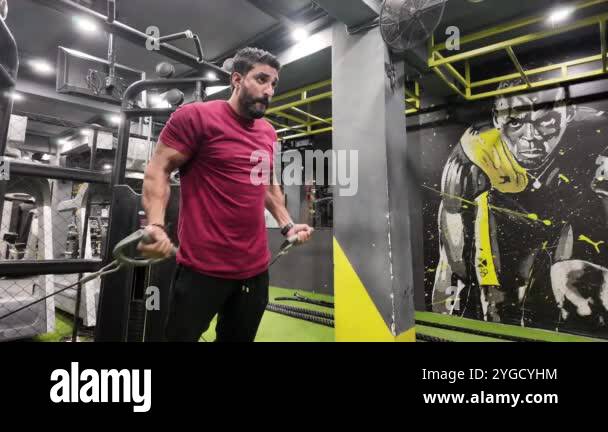Side View of Bodybuilder with Big Muscles Performing Cable Curls on ...