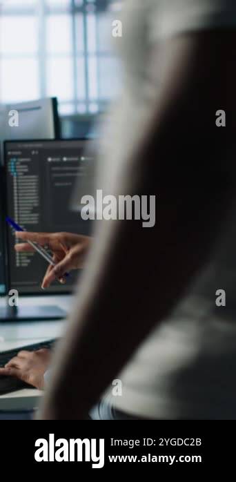 Engineer waiting at PC desk for checkup to be done on AI server room providing computing ...