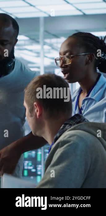 Technician doing brainstorming with colleagues to fix error in code affecting server room AI ...