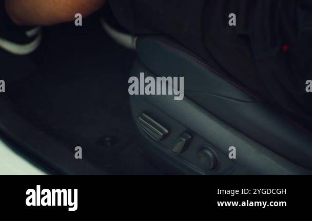 Close up of man in car adjusting driver seat using buttons. Person in ...