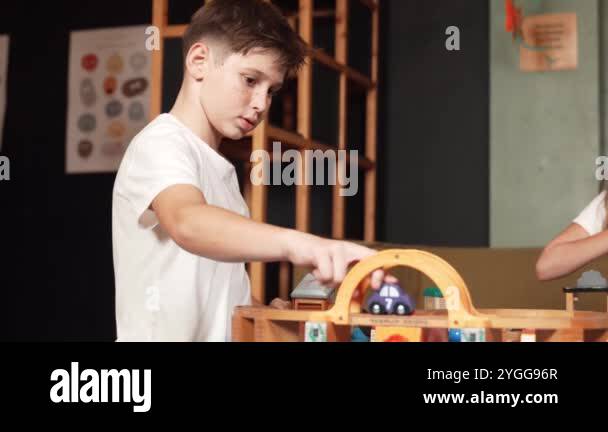Young caucasian smart boy playing car toy at playroom of kindergarten ...