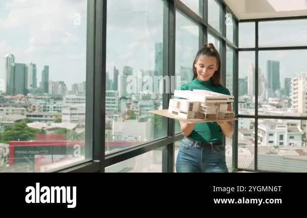 Young happy beautiful engineer check house model by turning left side ...