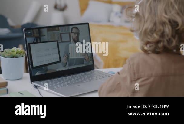 Over the shoulder view of child watching online lesson listening to ...