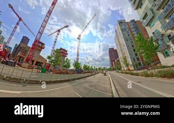A 360 panoramic view of tower cranes in action, lifting materials ...