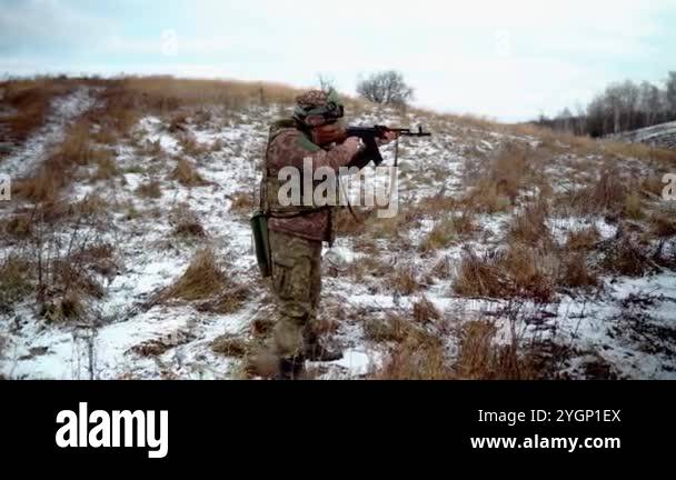 Soldiers practice shooting with machine guns on a military field ...