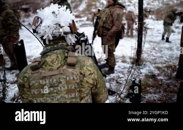Soldiers practice shooting with machine guns on a military field ...