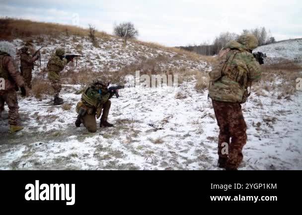 Soldiers practice shooting with machine guns on a military field ...