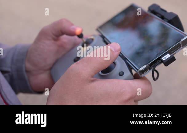 Hand of a Drone Operator man closeup while pilot a quadcopter remote ...
