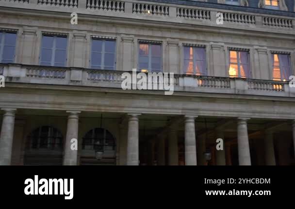 The detailed facade of Palais Royal in Paris, showcasing arched windows ...
