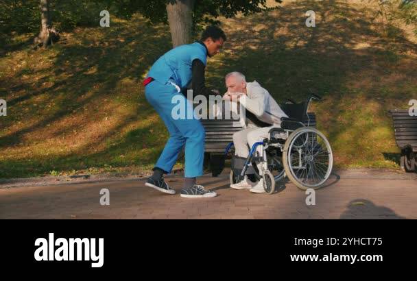 Hispanic doctor taking care of old disabled friend in wheelchair. Latin ...