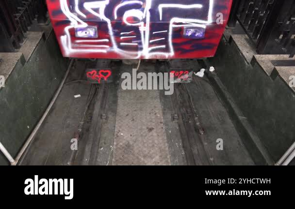 Close-up of a vibrant red cable car cabin featuring urban graffiti. The ...