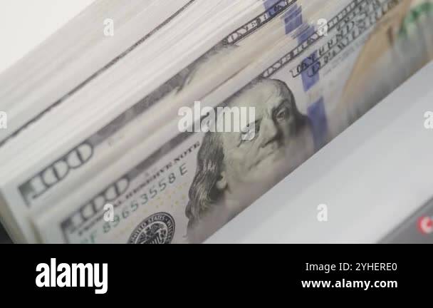Detailed view of 100-dollar bills in a cash counting machine, focus on ...