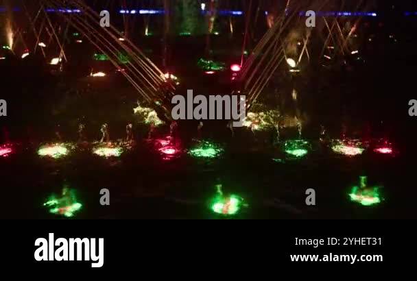 mechanical water fountain illuminated with colorful lights in slow ...