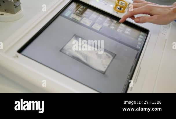 Close-up of doctor using digital touchscreen to operate X-ray machine ...