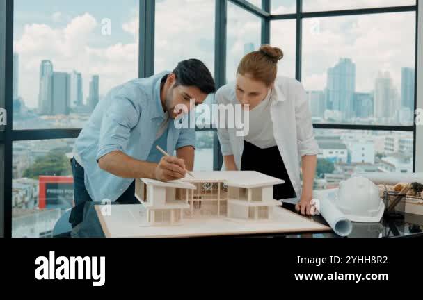 Skilled project manager pointing architectural model by using pencil ...
