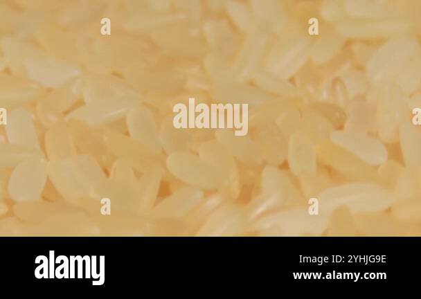 Dry Uncooked Parboiled Rice Rotating - Macro. Scattered Raw Long Grain ...