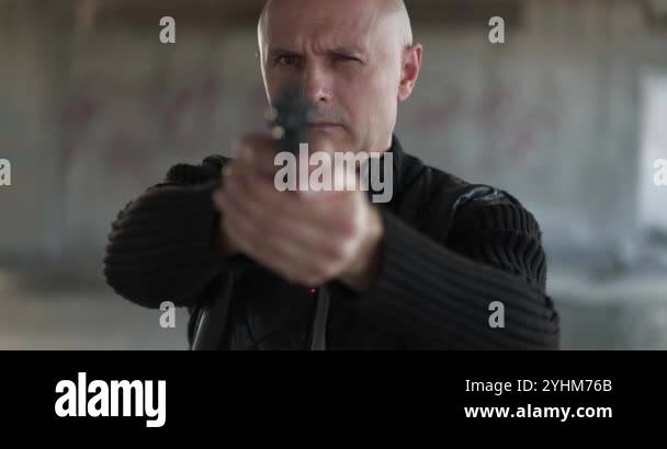 Man with revolver looks at the camera, red laser beam of the sight ...