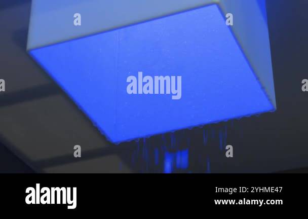 Snow falls from snowmaking apparatus. Snow generator. Factory snow ...