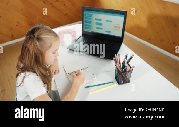 Little pretty caucasian girl doing classwork while showing a thumb up ...