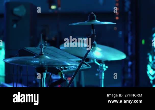 The stage is prepared with a drum set, cymbals, and musical instruments ...