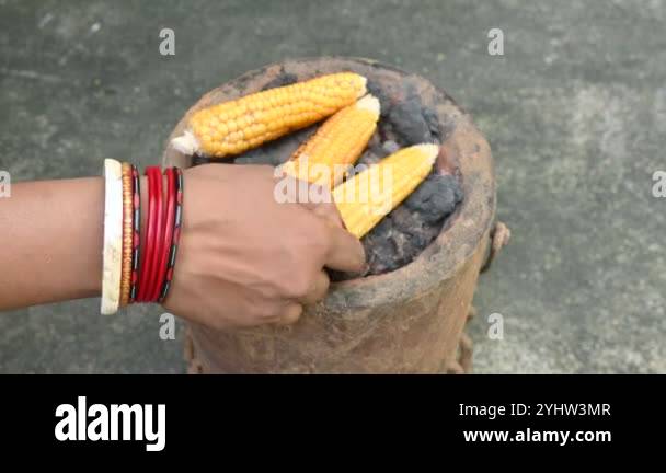 Corn cobs being grilled on a coal stove.Fresh roasted corncobs on coal ...