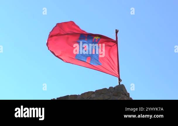 Slow motion of Aracena's iconic red flag with blue castle emblem waving ...
