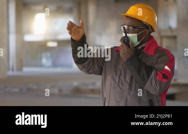 Slow Motion African american workman in yellow hard hat, goggles and ...