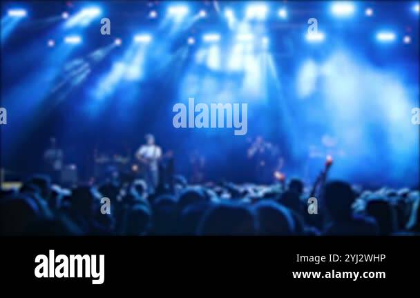 Live music event. Crowd at concert with raised hands and bright stage ...