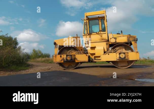 Yellow road roller compacted asphalt on new road. Road roller ...
