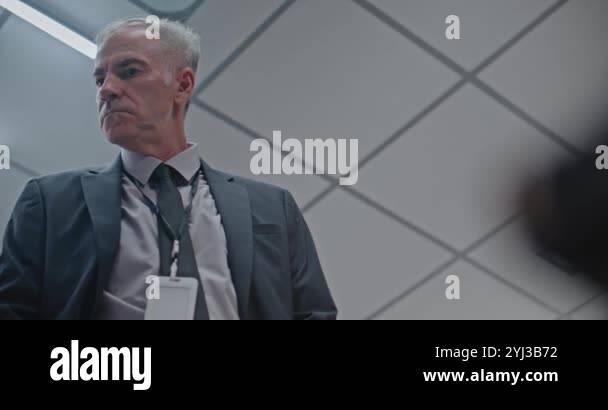 Low angle close up of serious male detective in suit looking at the ...