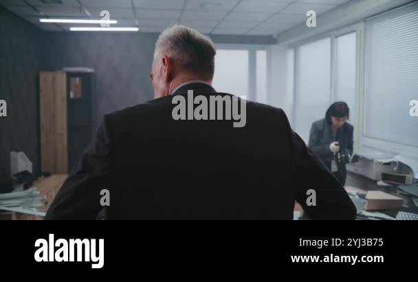 Office robbery case: Back view of male detective in suit examining ...