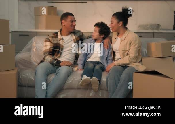 Happy family African American parents little son boy together on couch ...
