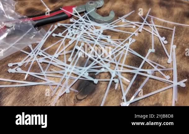 WHITE TIES. PLASTIC TIES. Bunch of white nylon cable ties on the brown ...