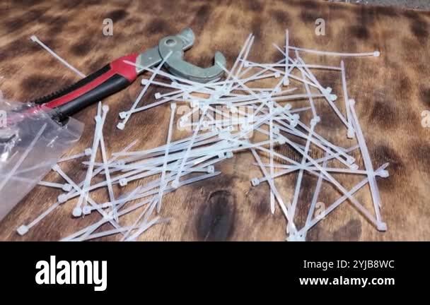 WHITE TIES. PLASTIC TIES. Bunch of white nylon cable ties on the brown ...