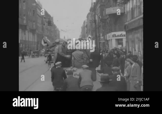 GERMANY - 1935 - Nazi soldiers drive around a German city waving ...