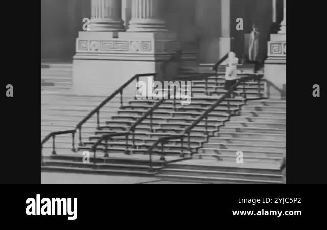 US - 1924 - in this silent comedy, a woman walks down the wide steps of an old building, aware ...