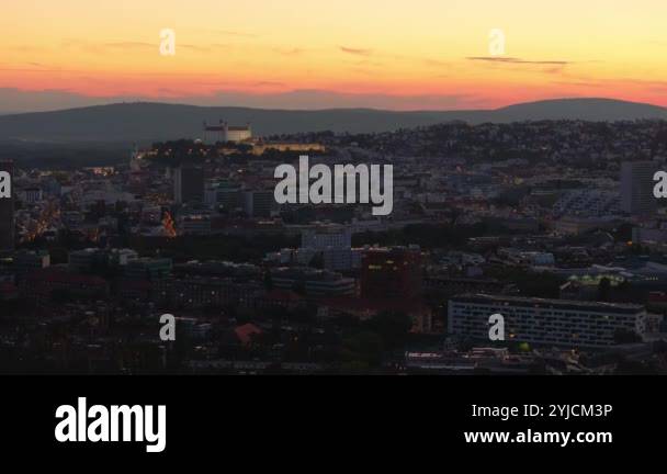 Bratislava, the capital of Slovakia, slowly lights up as the sun sets ...
