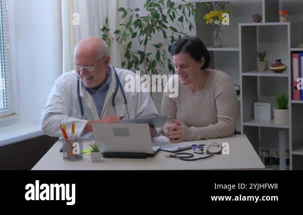 An elderly doctor in the office, receives a middle-aged woman, disabled ...