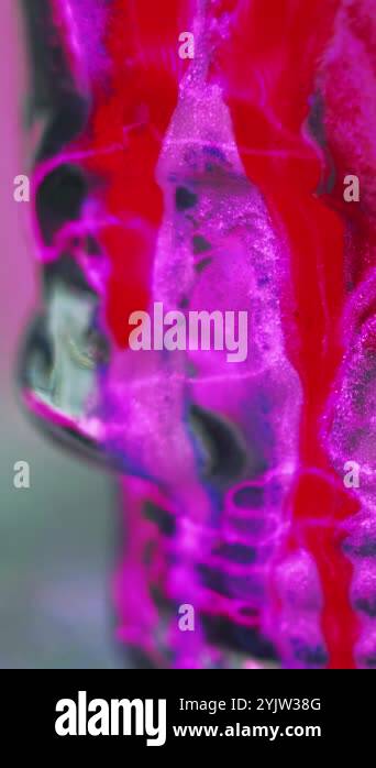 Vertical video. Glitter paint flow. Ink spill. Defocused red pink blue ...