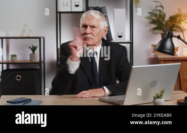 Caucasian senior businessman with laptop shakes finger and saying No be ...