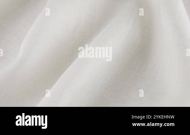 Soft folds of the white linen fabric rotates on the showcase. Top view ...