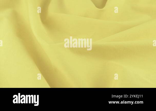 Top view of the soft folds of the tan yellow cotton fabric. The textile ...