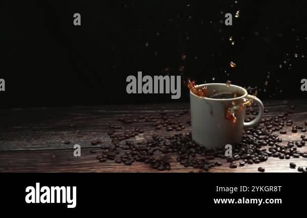 Super slow motion of falling ice dropping in to coffee cup and ...