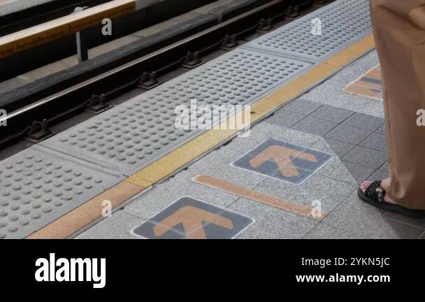 Feet low angle view on SkyTrain station platform with view of passenger ...
