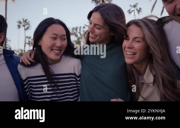 Diverse group of happy young people enjoying time standing laughing ...