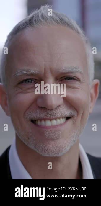 Vertical. Close up smiling mature business man looking positive at ...