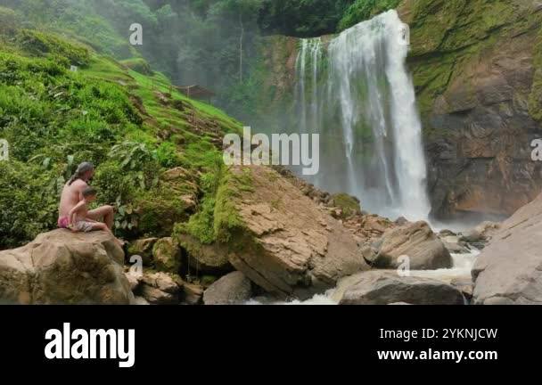 A father and son admire the stunning waterfall in Costa Rica ...