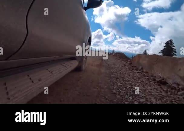 Muddy car is driving along muddy road in countryside, slowly making its ...