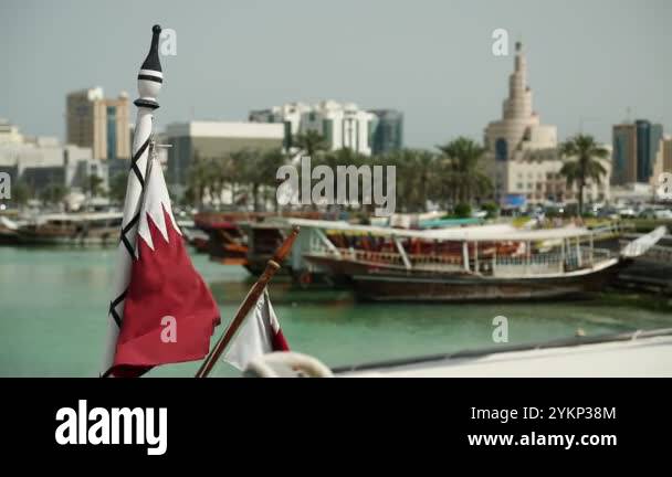 Flag of Qatar on the boat in harbour, islamic cultural center Fanar in ...