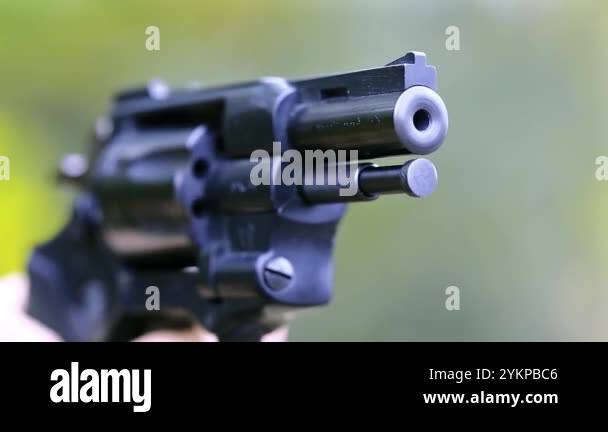 Shots from a revolver. Man shoots a revolver. Shots from a black pistol ...